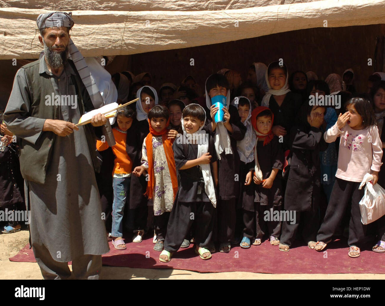 An Afghanistan teacher stands with his students at an assembly held at ...