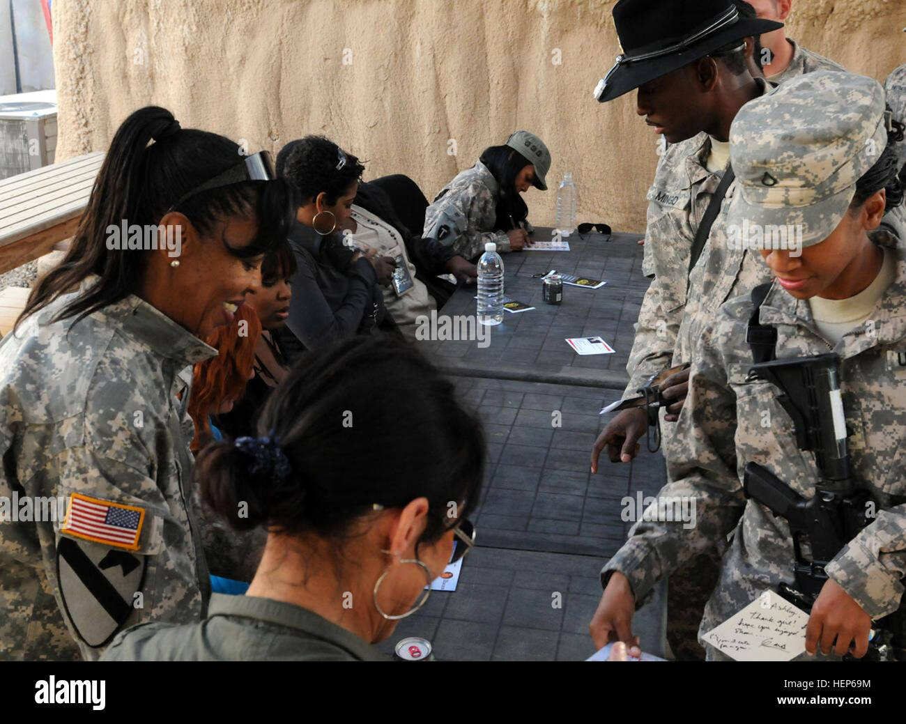 Soldiers file along a table to get autographs from the ladies of an all ...
