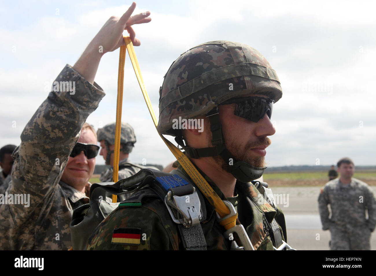 A U.S. Army jumpmaster inspects a parachute for a German paratrooper ...