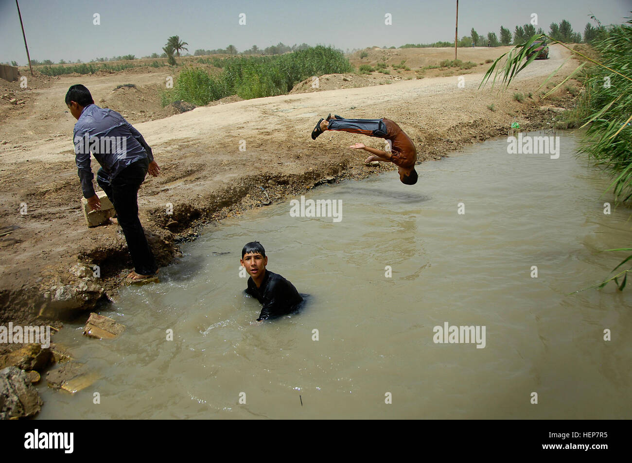 Iraqi boys swim in the murky waters of a small pond near Awad, Iraq ...