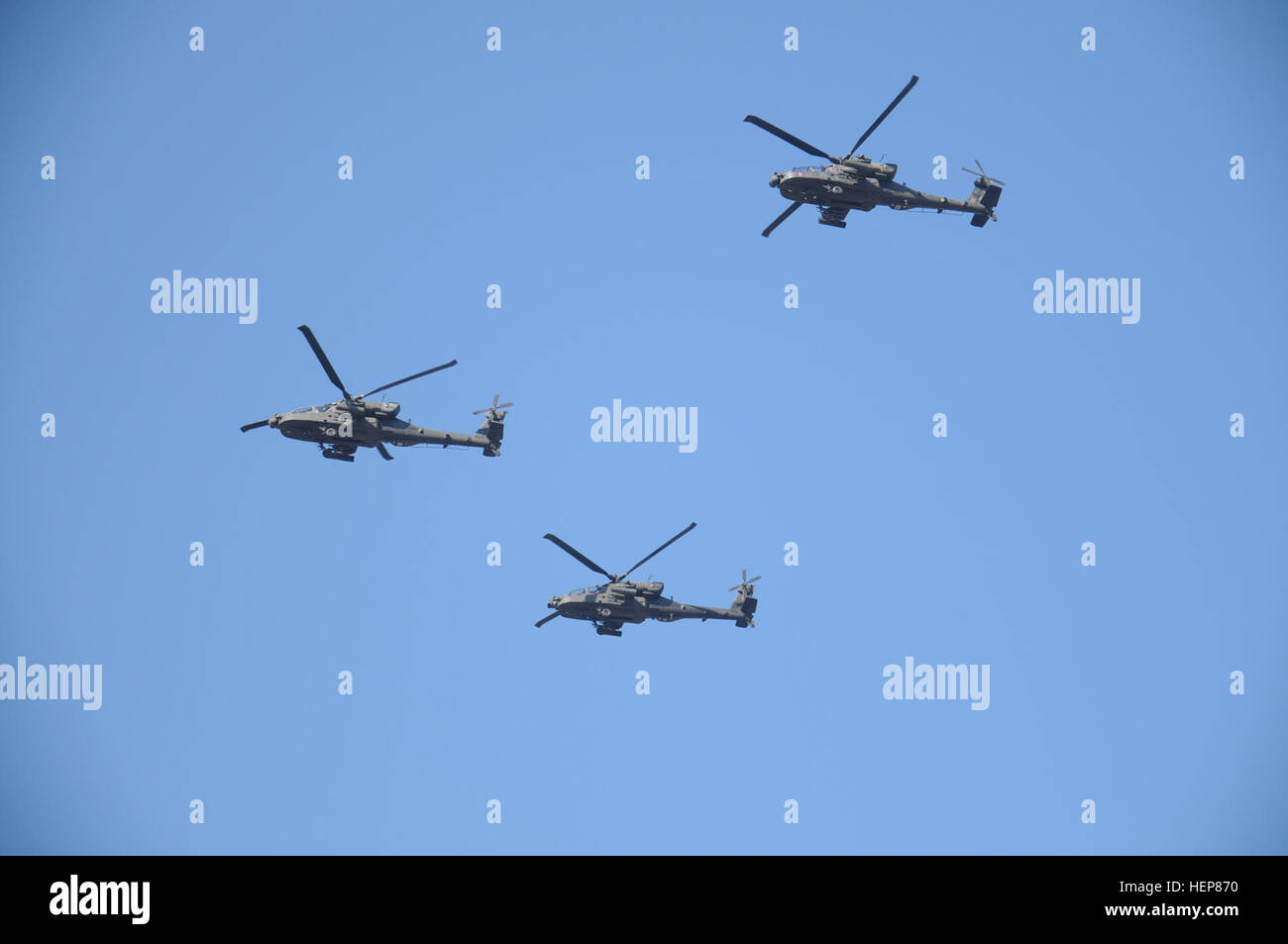 Three U.S. Army AH-64 Apache attack helicopters fly in formation over a ...