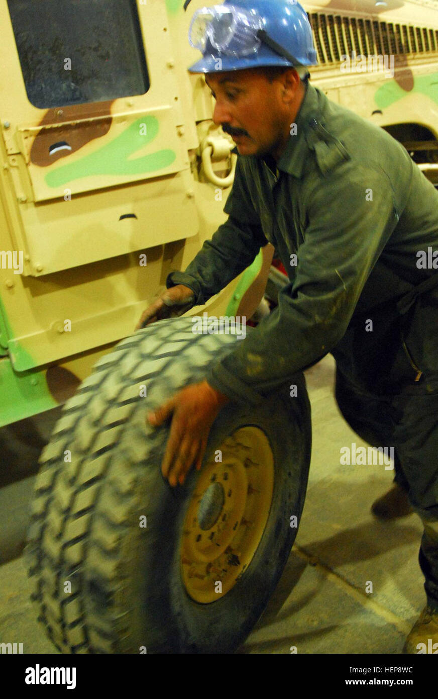 An Iraqi army mechanic rotates Humvee tires as he and his team races to ...