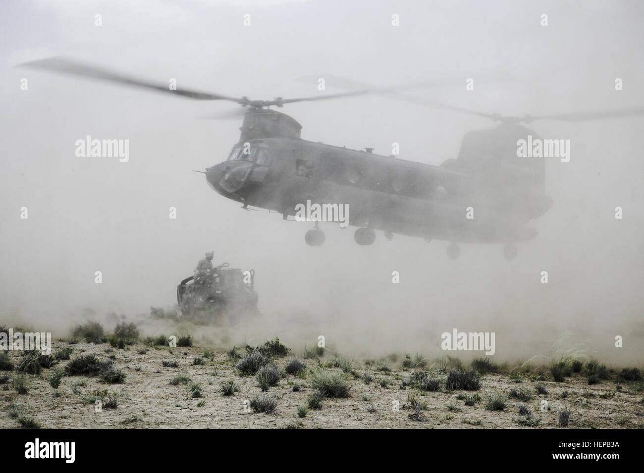 A U.S. Soldier prepares to hook up a John Deere skid steel loader to a ...