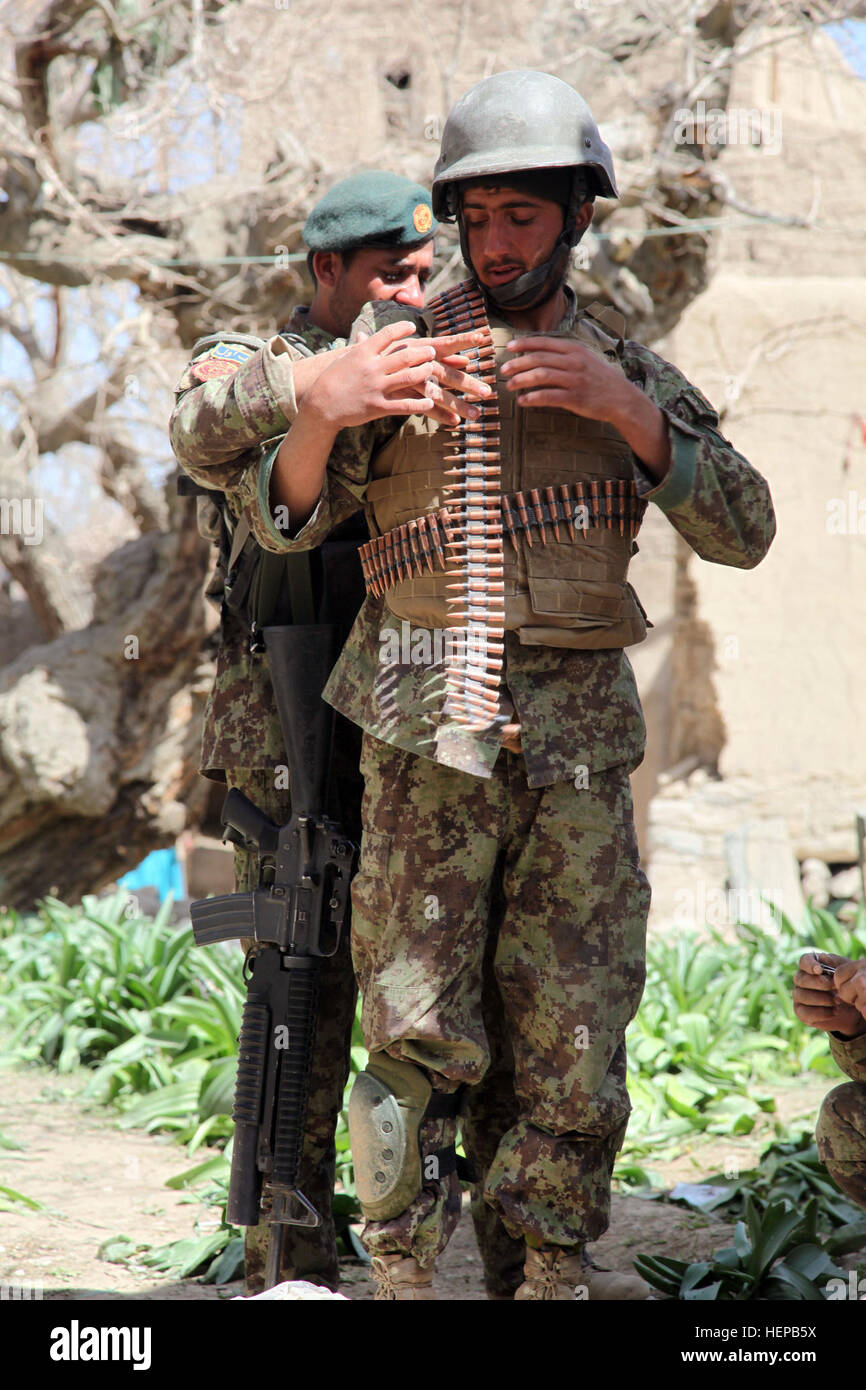 An Afghan National Army soldier gets help loading his equipment and ...