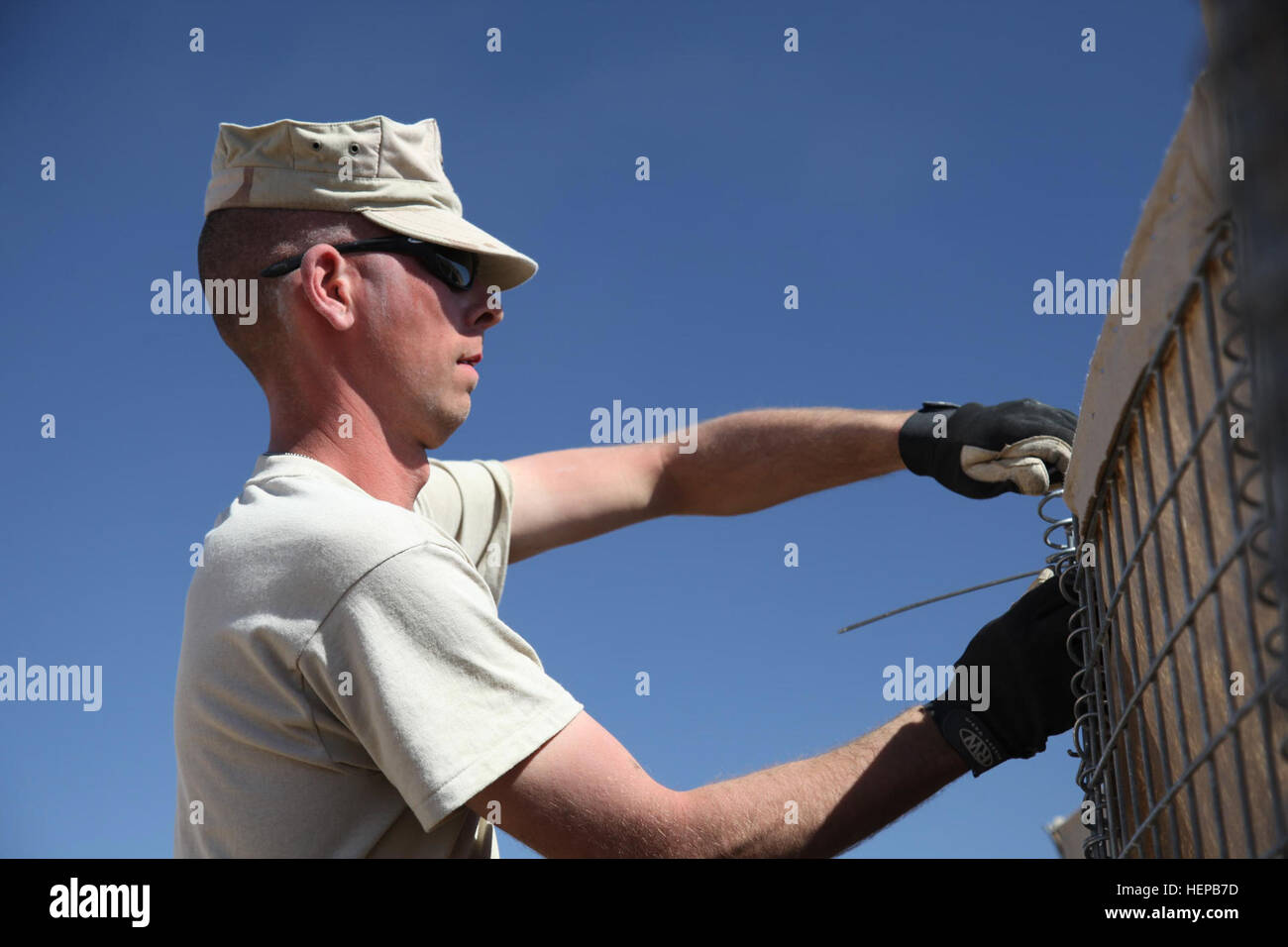 U.S. Navy Petty Officer 1st Class, Travis Dunbar, a Seabee steel worker ...