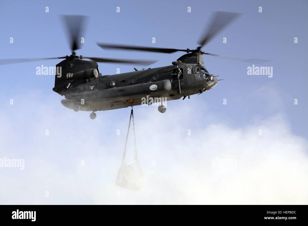 A CH-47 Chinook helicopter prepares to unload a HESCO sling load in the ...