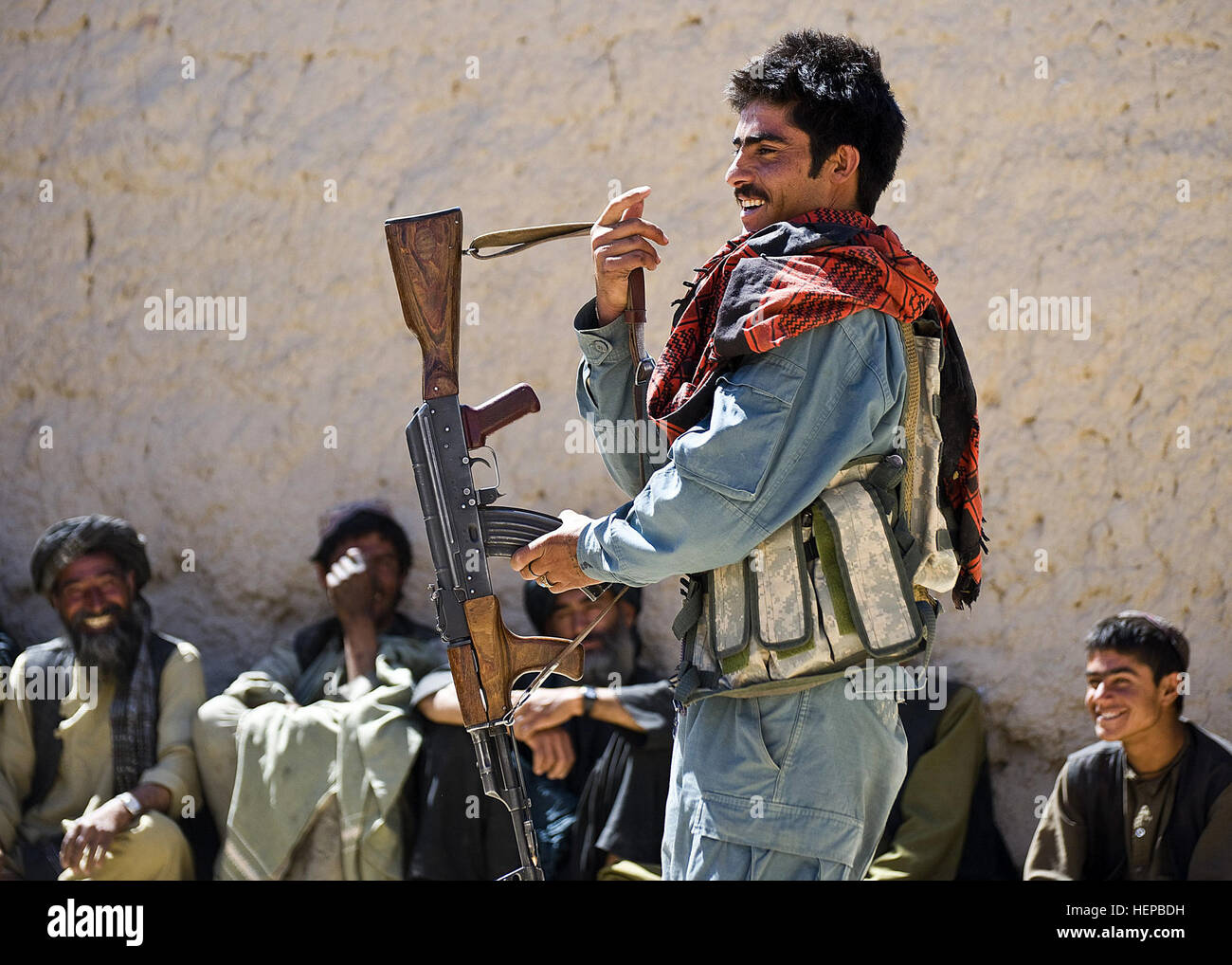 A member of the Afghan National Police laughs with villagers during a ...