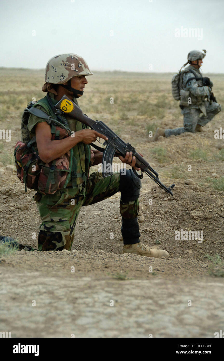 An Iraqi Army Soldier pulls security with U.S. Army Staff Sgt. Anthony ...