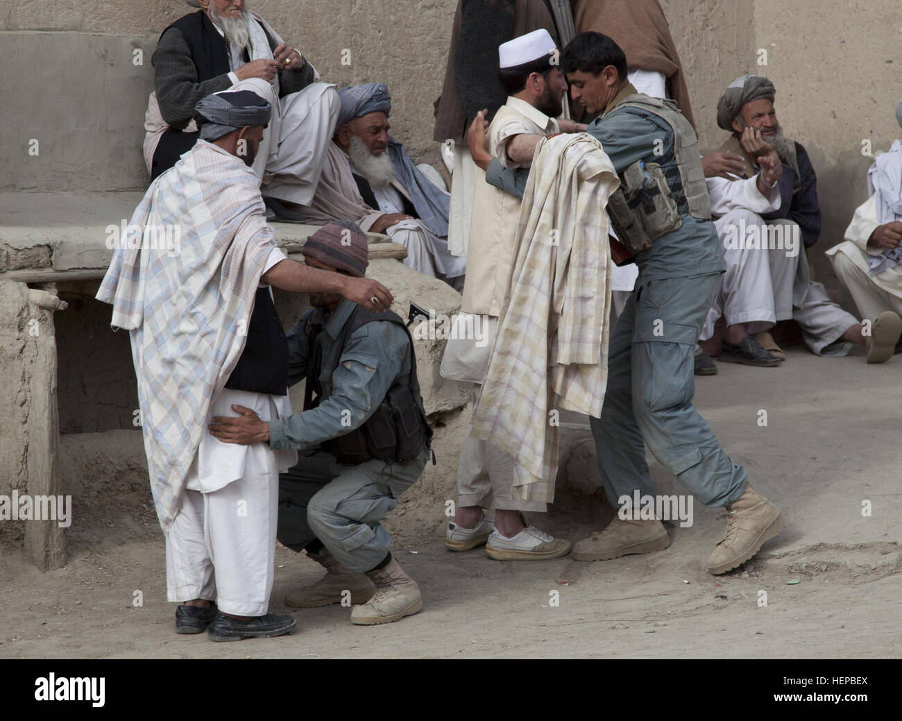 Afghan National Policemen search villagers during a patrol in Sayed ...