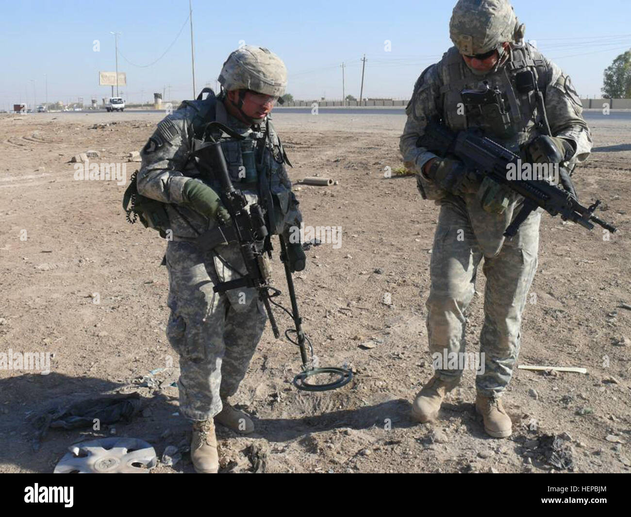Spc. Mario Macias (left), from Fort Worth, Texas, uses a metal detector ...
