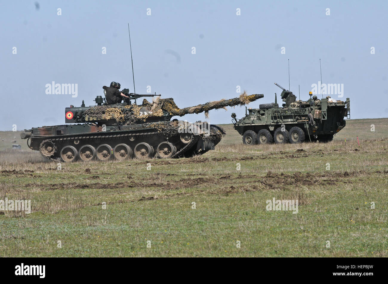 A Romanian TR-85 Main Battle Tank (middle,) maneuvers past a Stryker ...
