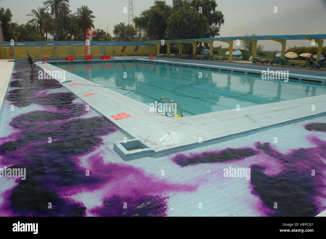 Worker at the al-Amana swimming pool put purple dye into a wading pool ...