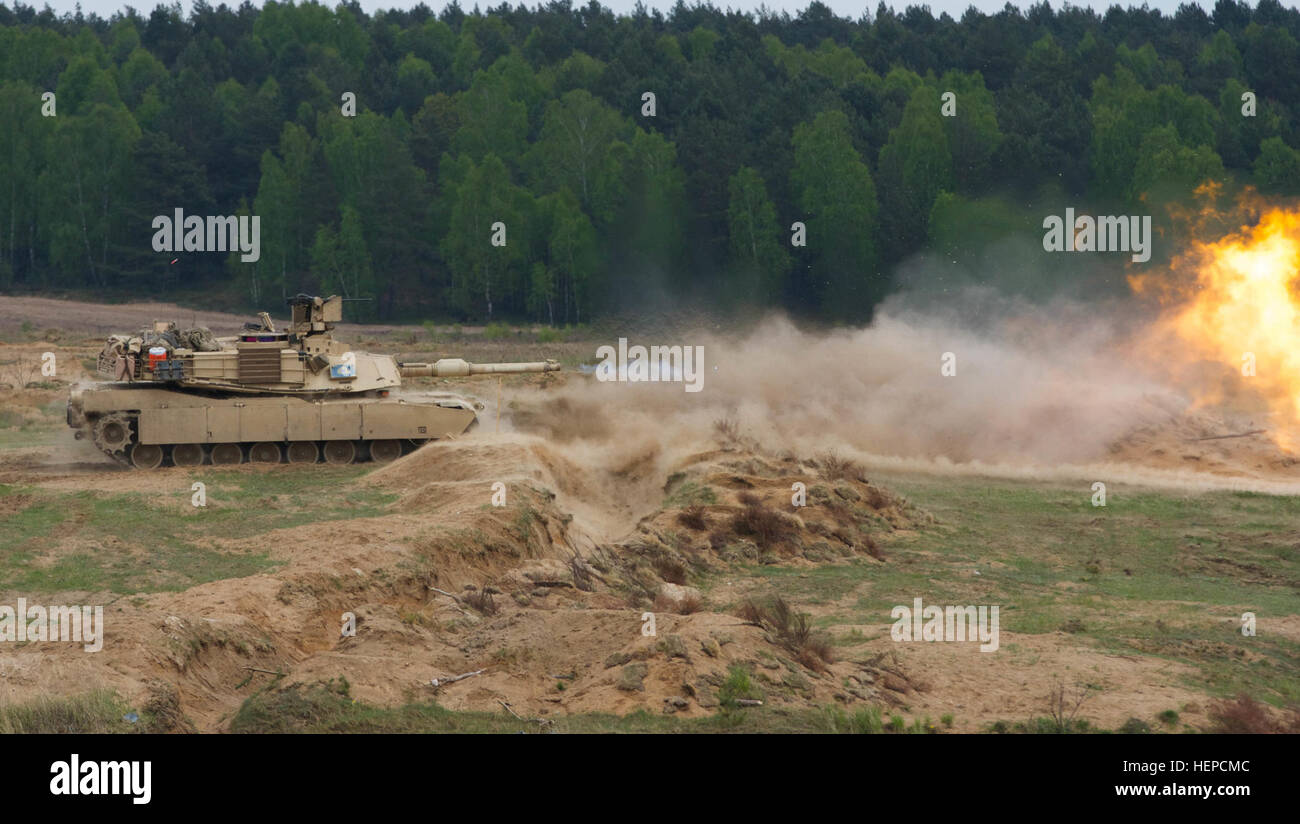 The crew of an M1A2 Abrams Main Battle Tank fires their main gun at a ...