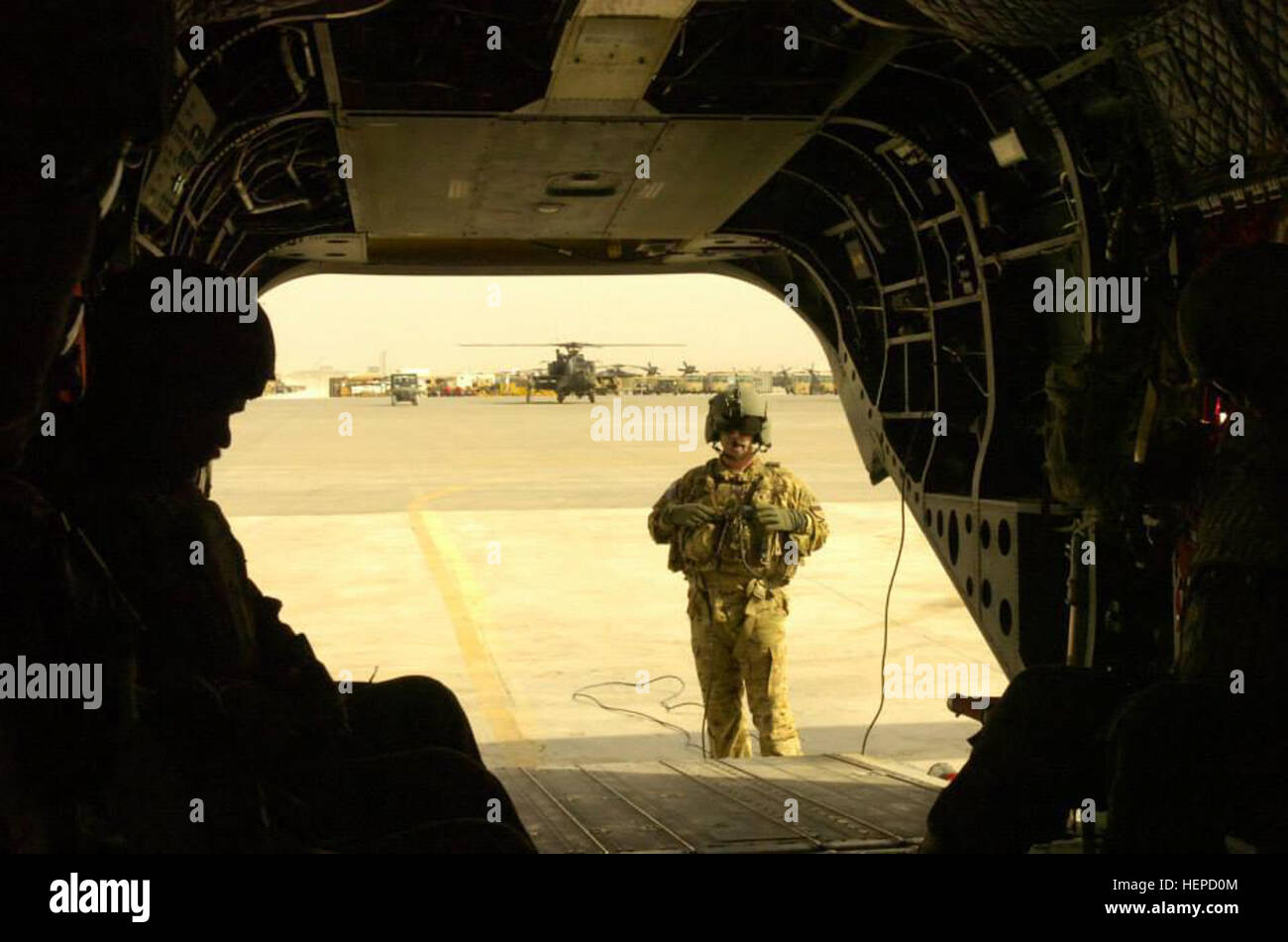 A CH-47 Chinook helicopter crew member conducts pre-flight procedures ...