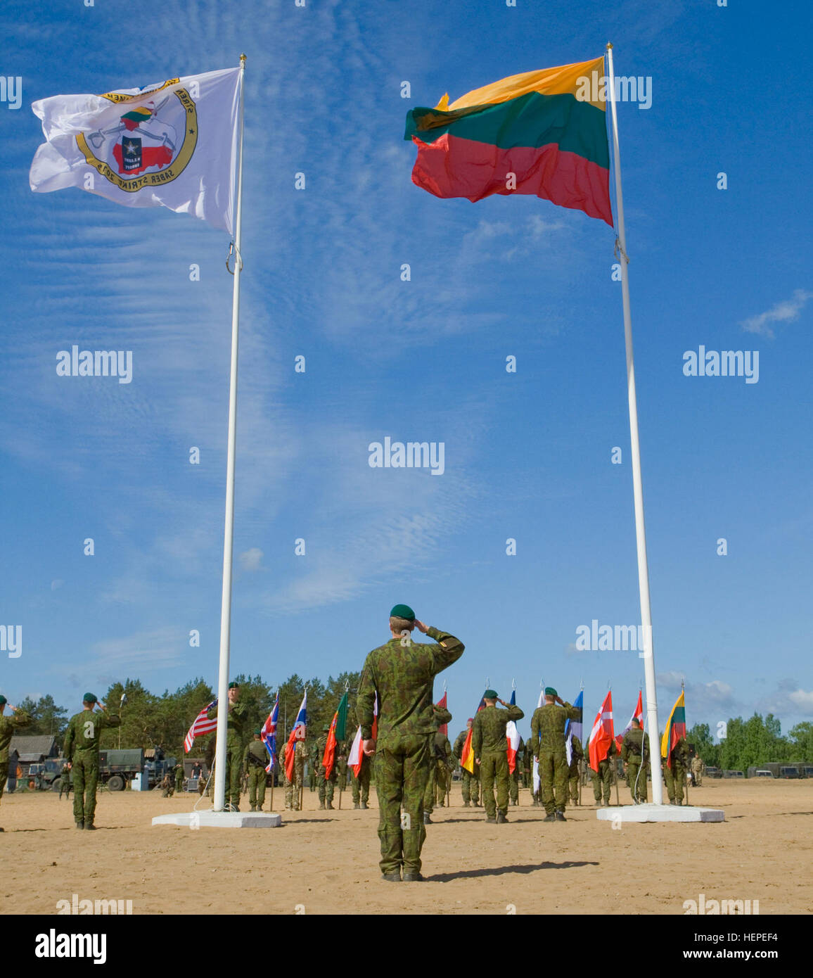 The Lithuanian flag, right, and the Saber Strike flag are run up by ...