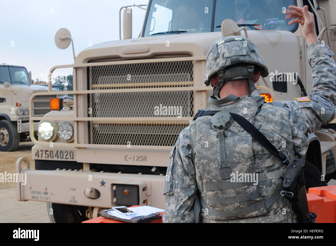 A Soldier from the 475th Quartermaster Group guides a vehicle into ...