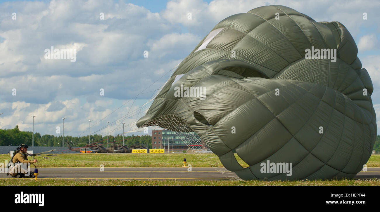 A Latvian soldier controls his parachute during joint airborne training ...