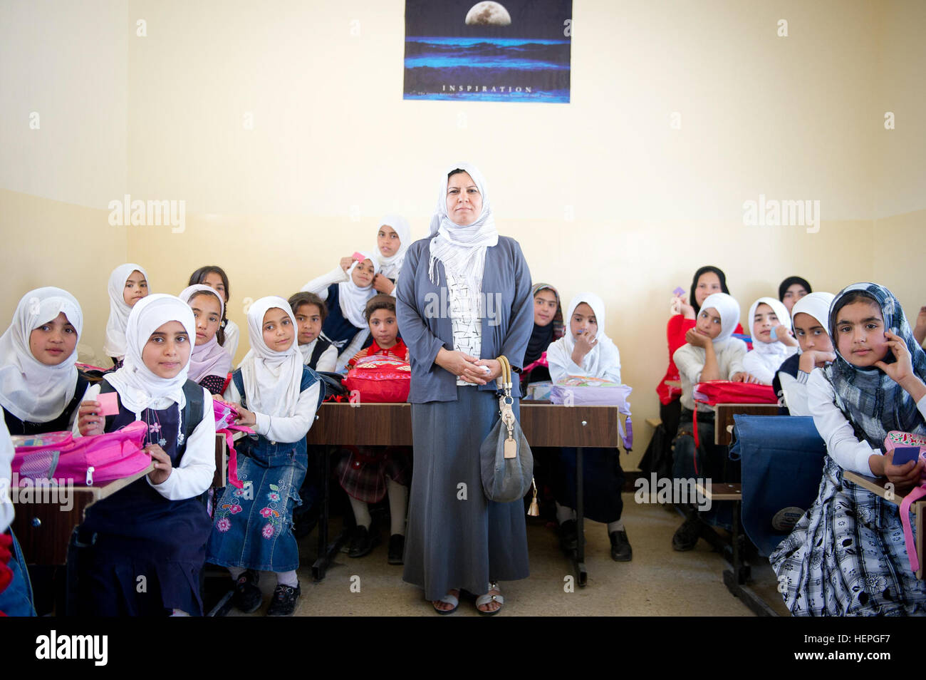 An Iraqi school teacher and her class poses for a photo on the day ...