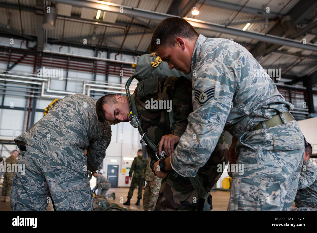 U.S. Air Force paratroopers assist French paratroopers as they put on ...