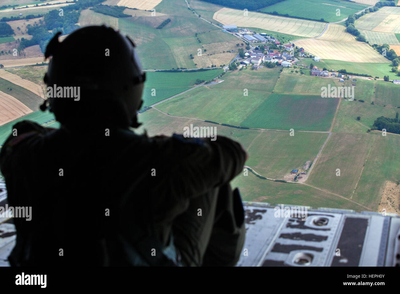 A U.S. Air Force Loadmaster sits on the ramp of a C-130 Hercules during ...