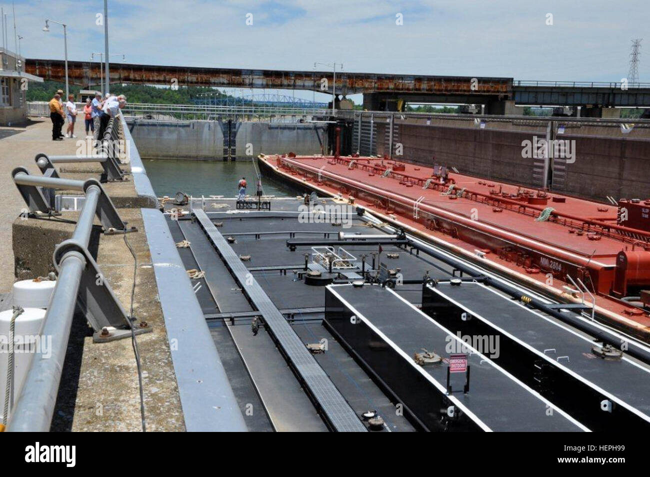 Visitors observe a fuel barge maneuvering alongside another barge to ...