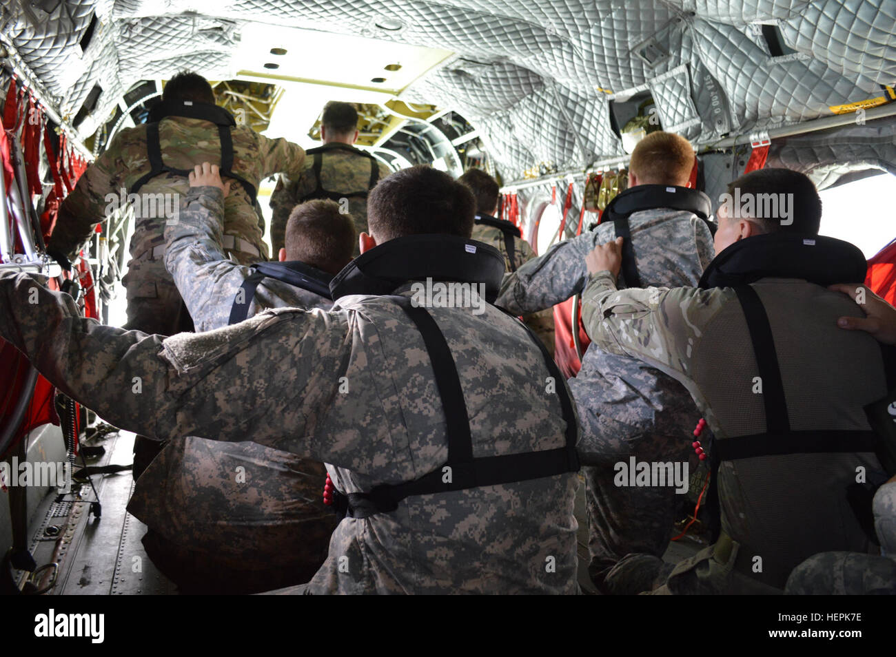 U.S. Army Soldiers stand ready to jump into the ocean from a CH-47 ...