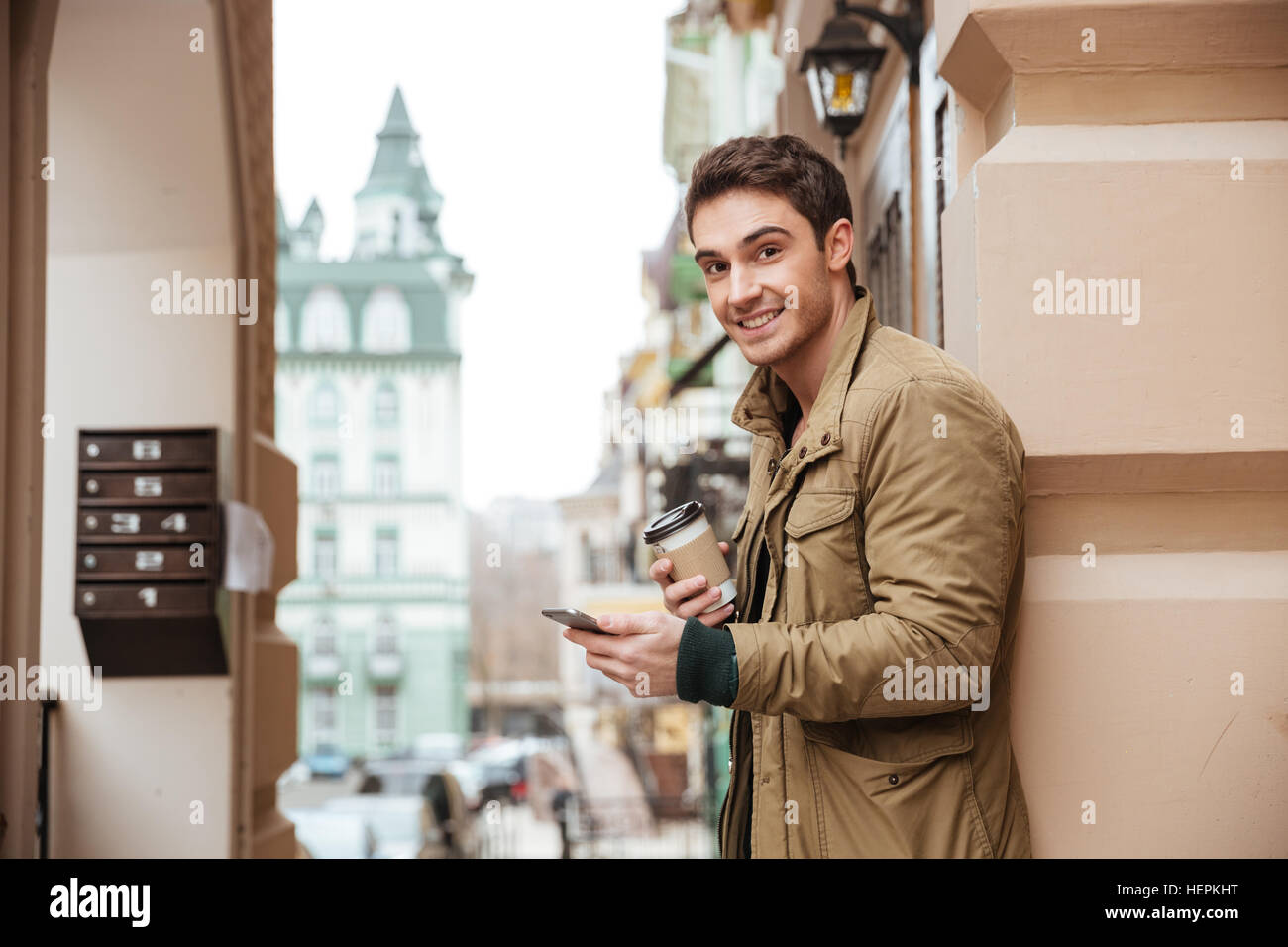 Portrait of handsome cheerful man walking on street and chatting by his ...