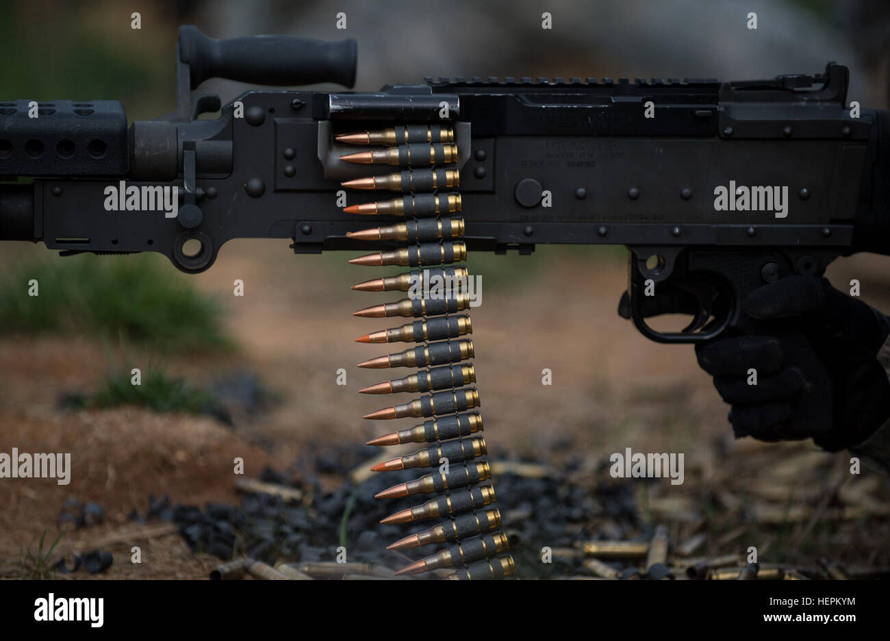 A belt of 7.62 mm rouns feeds into an M240B machine gun at a ...