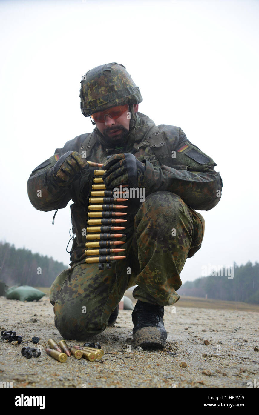 A German soldier loads cartridges in a .50 caliber machine gun ...