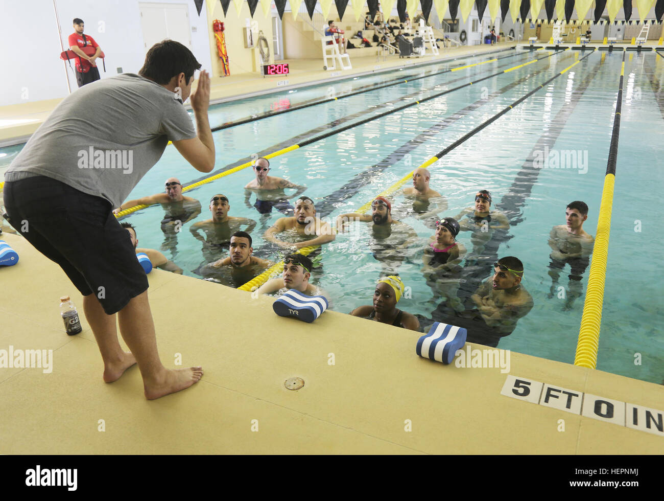 U.S Army active duty and veteran athletes gather around as swim coach ...