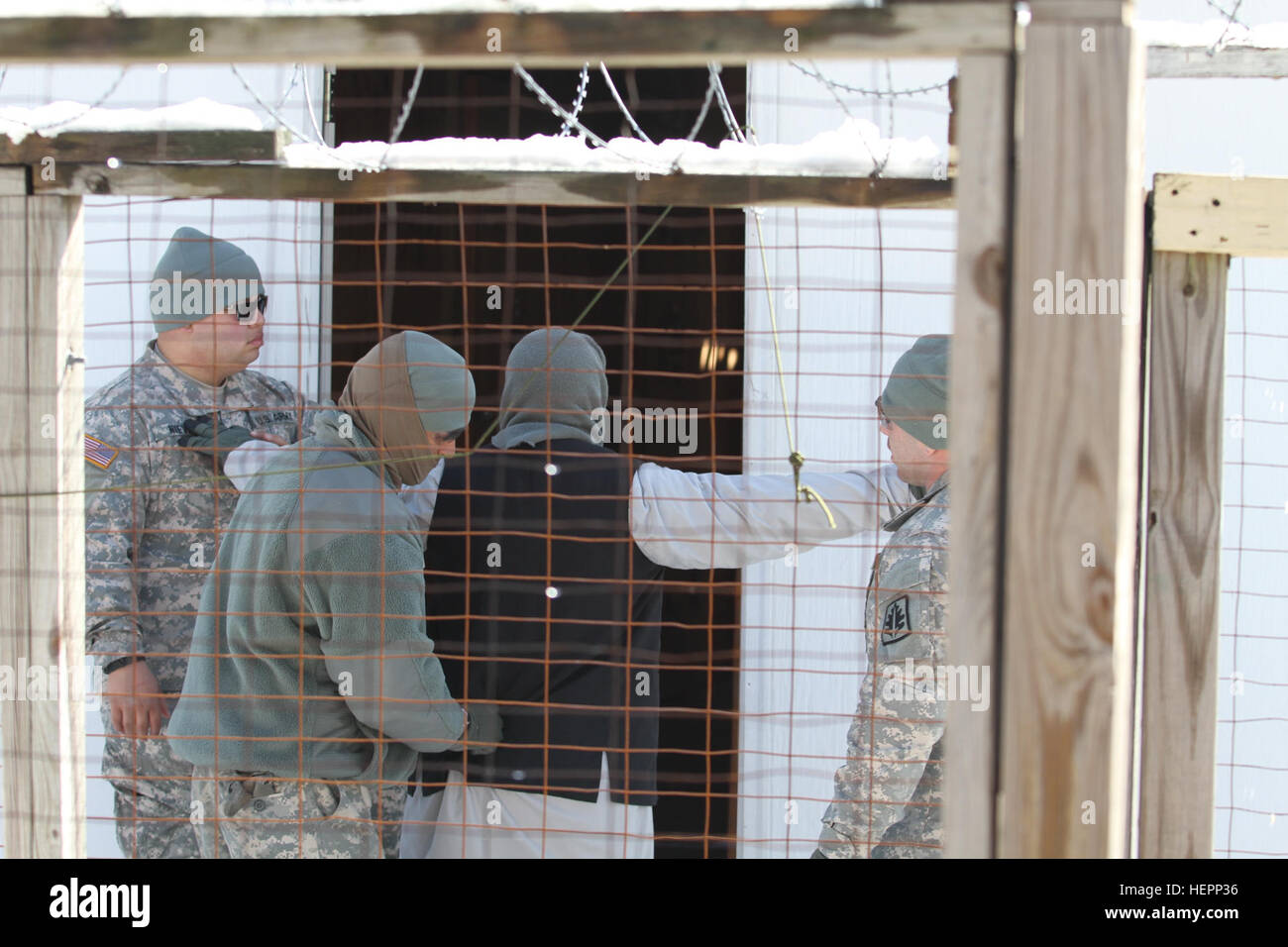 A prisoner is patted down and searched by three U.S. Army Soldiers from ...