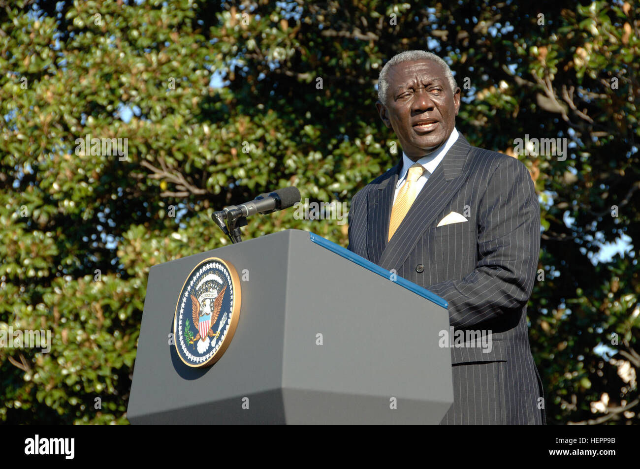 President of Ghana, John Agyekum Kufuor, stands behind the podium ...