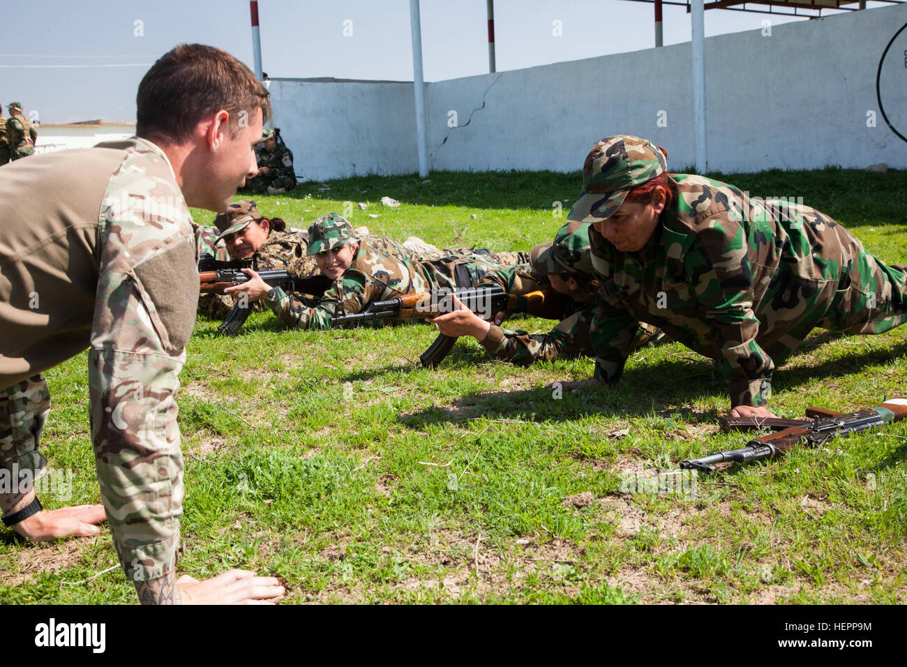 A Female Peshmerga soldier does push-ups with a British instructor near ...