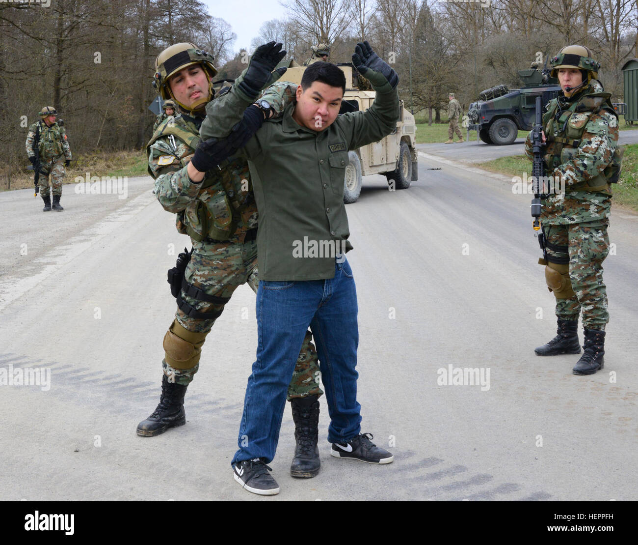 Macedonian soldiers conduct a body check with a captured member of the ...