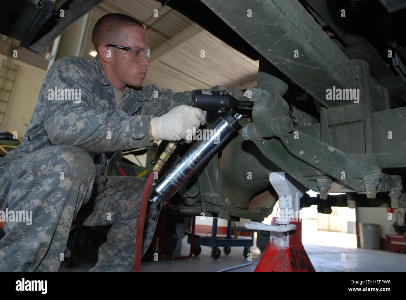 A U.S. Army mechanic performs maintenance on a High Mobility ...