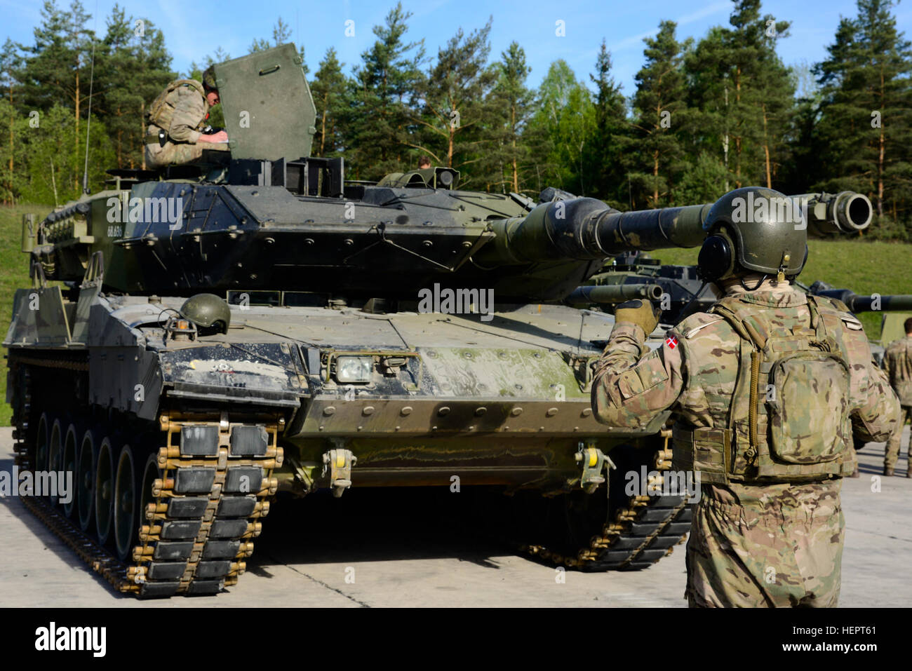 A Danish soldier ground guides a Danish Leopard tank, during the Stock ...