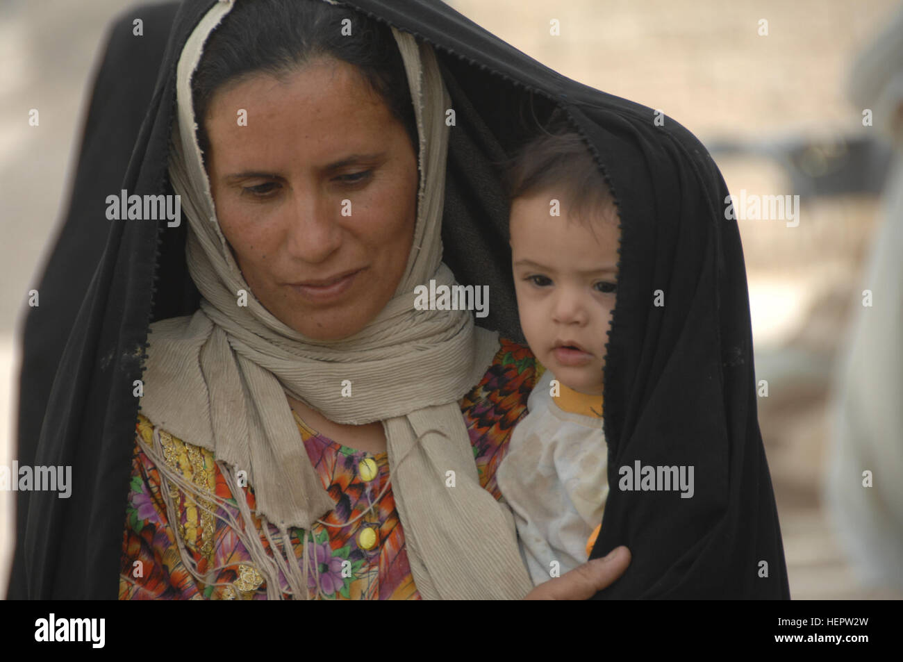 An Iraqi mother and child patiently wait to receive aid from 5th Iraqi ...