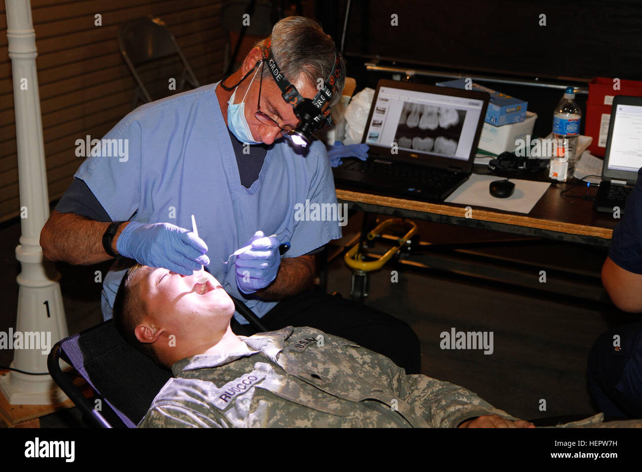 Dr. Charles Wiseman DDS, performs a dental exam on Spc. Christopher ...