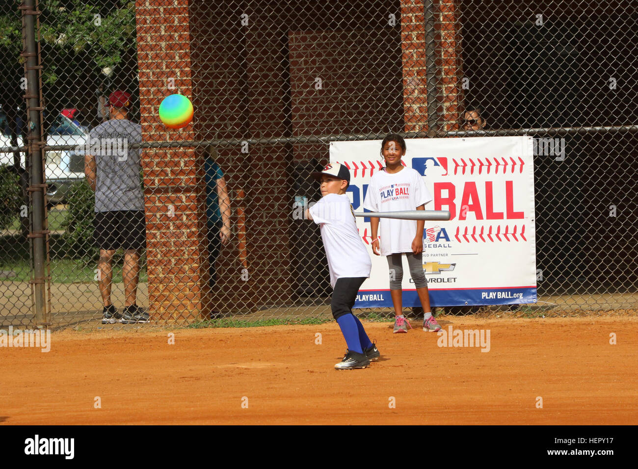 A young baseball fan swings for a hit while participating in a friendly ...