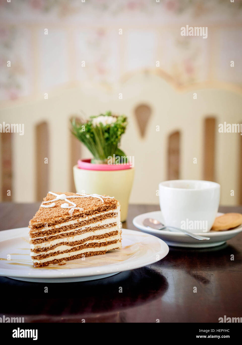 Slice of layered french cake and cup of coffee Stock Photo - Alamy
