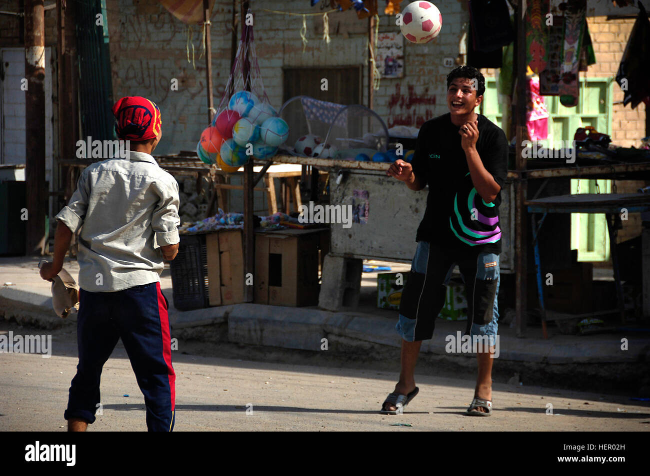 Young Iraqi men play with a soccer ball outside of an Abu Ghraib ...