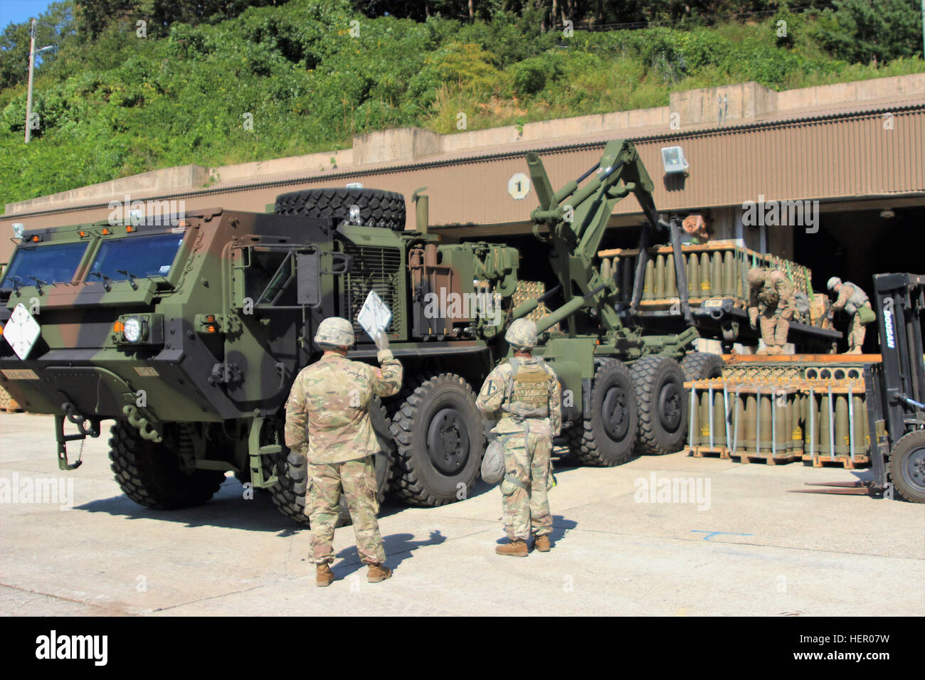 Soldiers pull a loaded flat rack off the loading dock with an Oshkosh ...