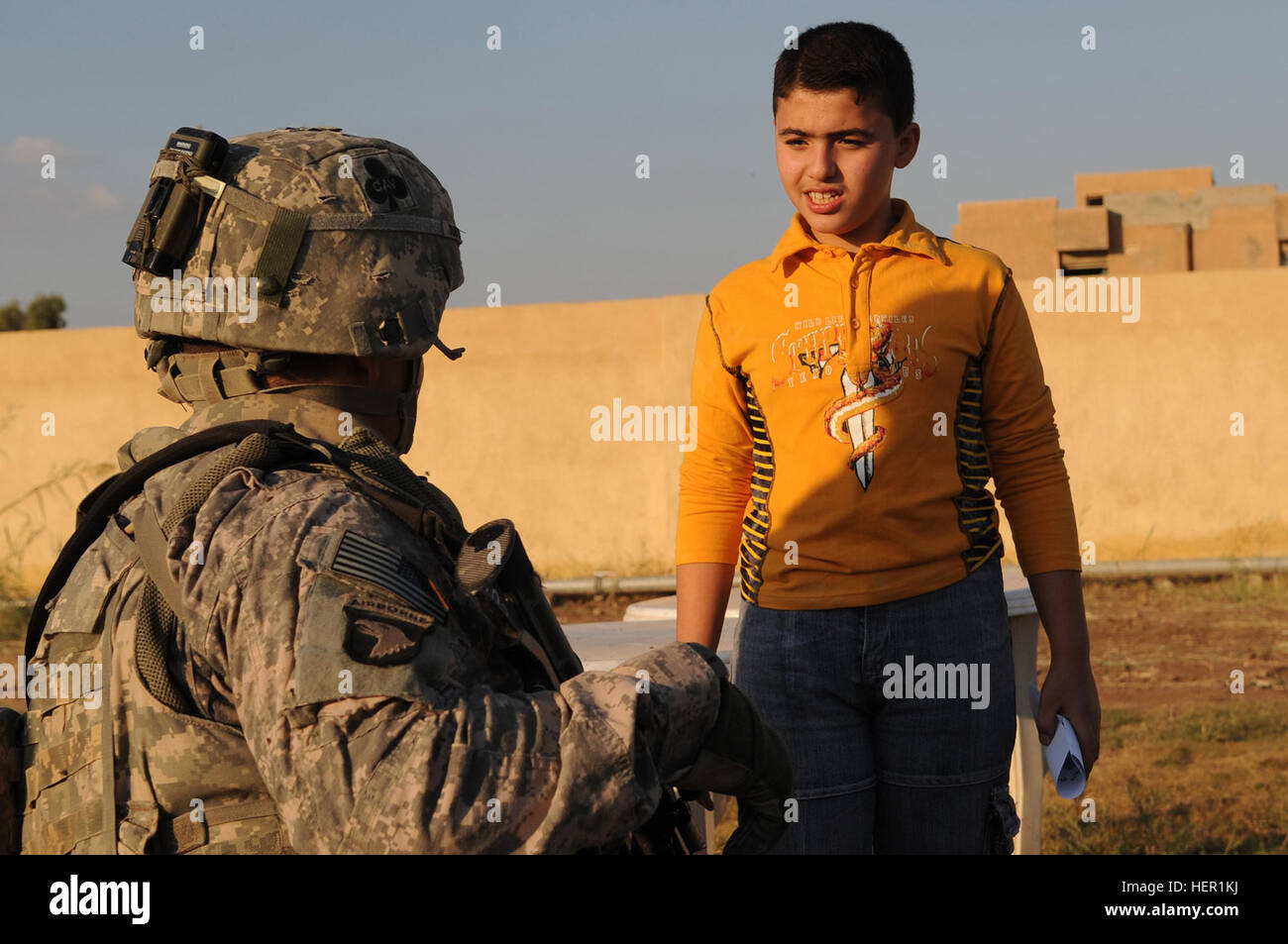 An Iraqi boy from Balad, Iraq, talks with U.S. Army 2nd Lt. Matt Burton ...