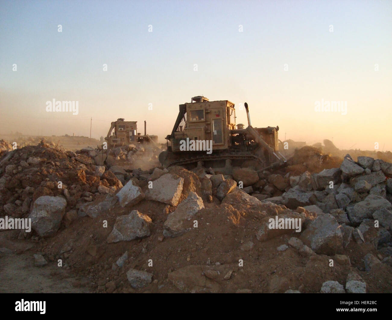 Two 25-ton bulldozer operators push massive piles of debris off the ...