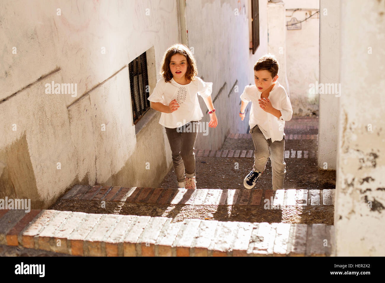 Boy and girl running up stairs hi-res stock photography and images - Alamy