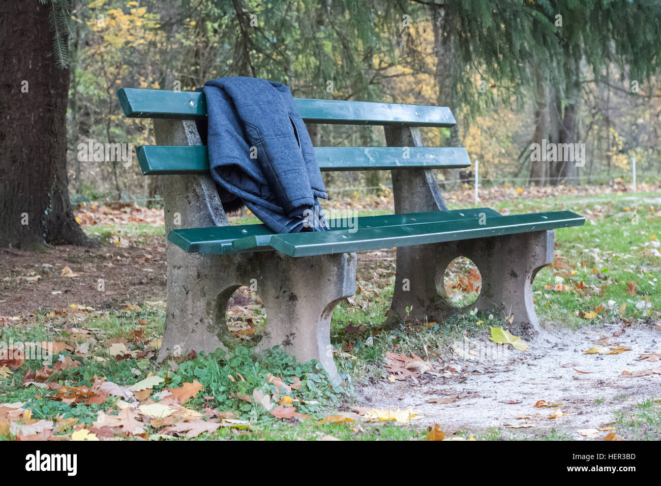 Green bench in the forest with nature in the background and jacket on ...