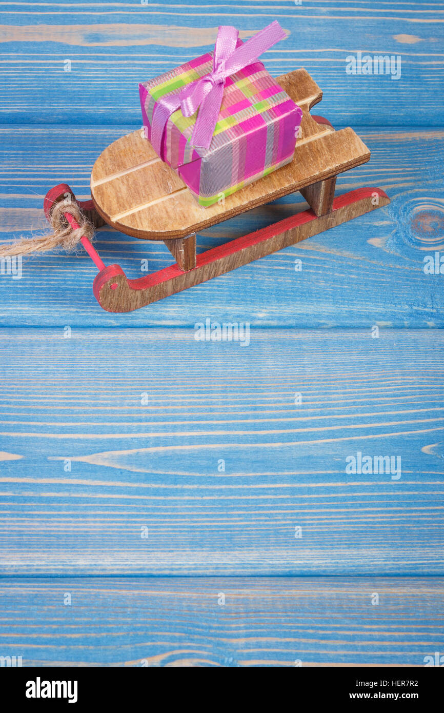Wooden sled and wrapped colorful gift with ribbons for Christmas or ...