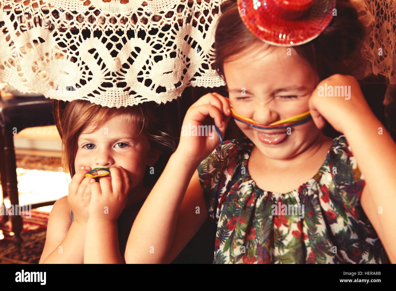 Party Girls eating sweet and sour candy spaghetti under the table Stock ...