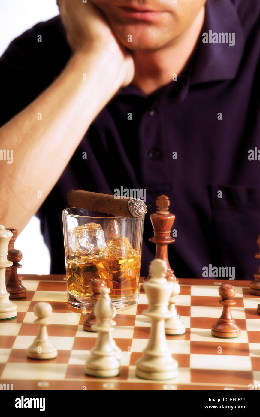 Chess player playing a game of chess, a glass of whisky and a cigar ...