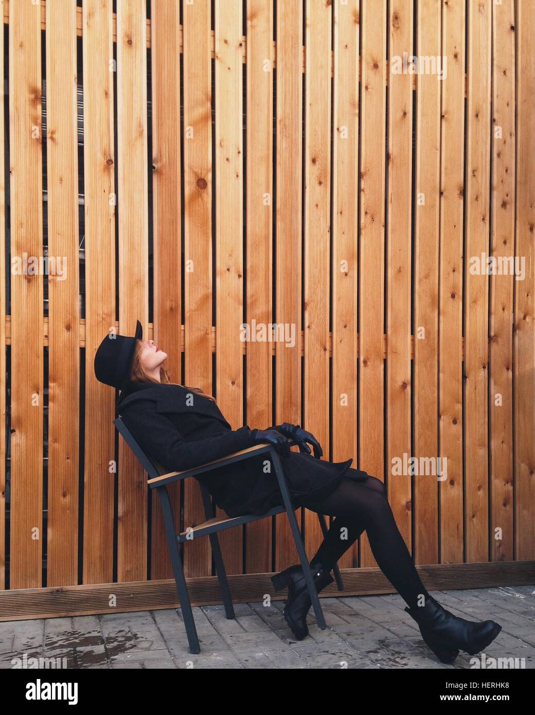 Woman sitting on a chair leaning back Stock Photo - Alamy